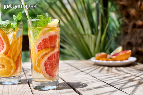 Summer refreshing lemonade drink with grapefruit, lemon, orange slices and mint. Fresh healthy ...