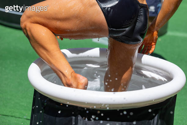 Boy immersing himself in little Circular Pool Filled with Water and Ice ...