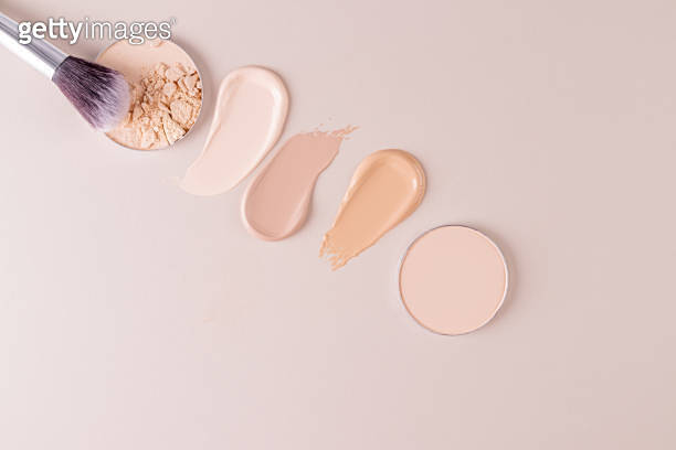 Three swatches of liquid foundation powder, two blocks of compact ...
