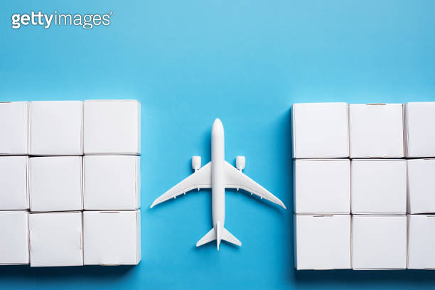 White airplane model placed with white cargo boxes on a bright blue ...