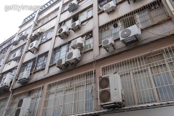 a building facade in bad condition with bars on the windows and with ...