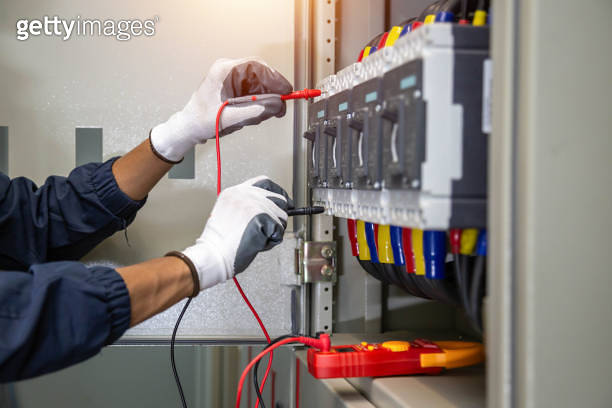 Electricians use electric meters to check equipment in electrical ...