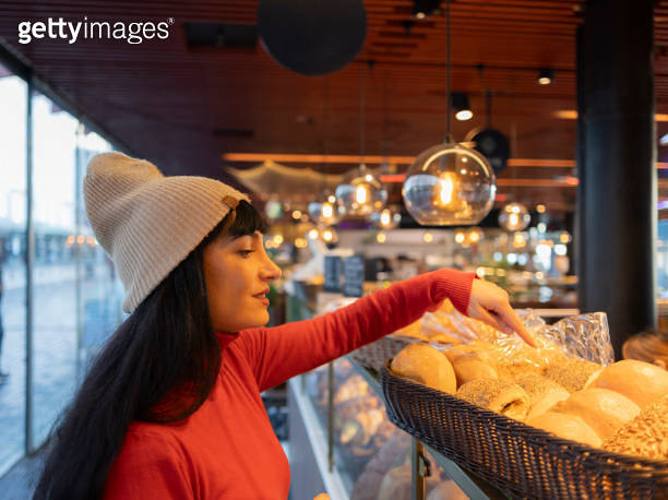 Woman Selecting Bread at Indoor Market 이미지 (2137679374) - 게티이미지뱅크