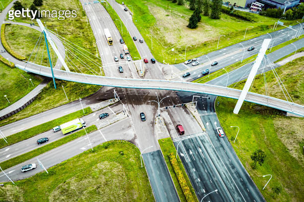 Traffic at a junction with a winding bicycle path bridge seen from ...