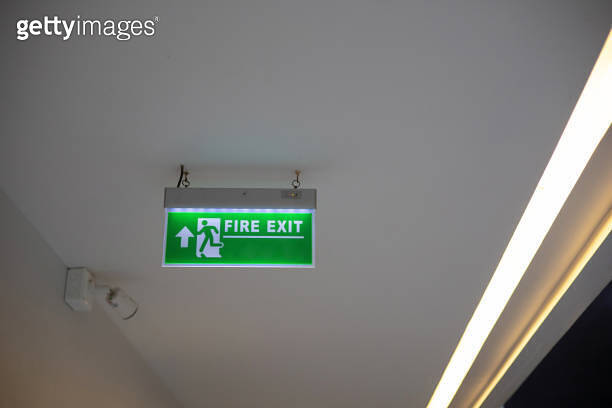 Green signs indicating fire exits installed in the building. except ...
