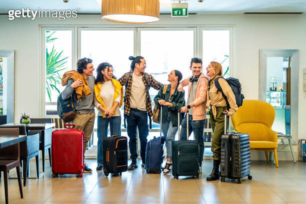 Young group of tourists with suitcases arriving at youth hostel guest ...