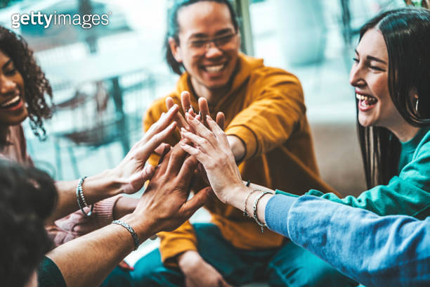 Group of young people stacking hands together - Friends with stack of ...
