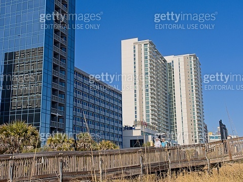 A couple walks the elevated boardwalk of Myrtle Beach with the high ...