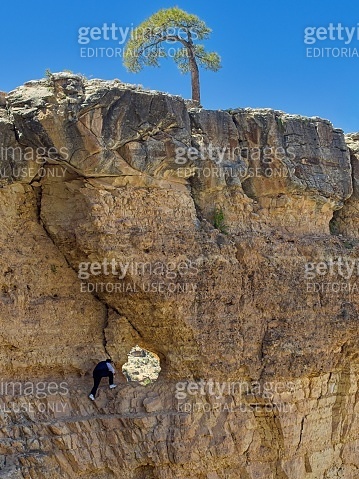 A man scrambles along a restricted access cliff area along the Bright ...