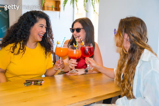 Friends toasting with cocktails in a bar in summer (1963407963) - 게티이미지뱅크