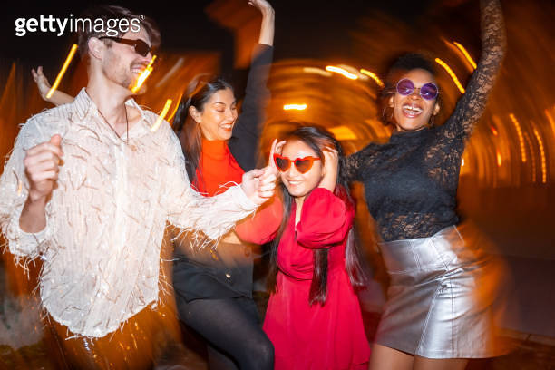Four multi-ethnic friends partying in the street at night 이미지 ...