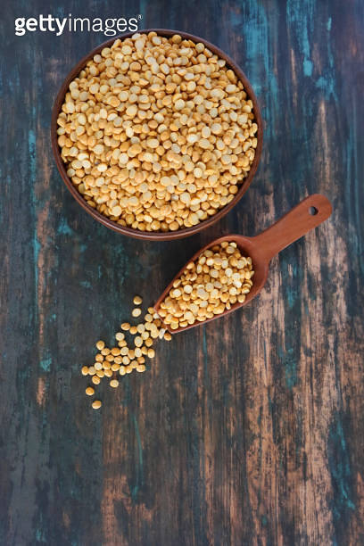 Image of pile of split yellow lentils (pigeon peas) in orange-brown ...