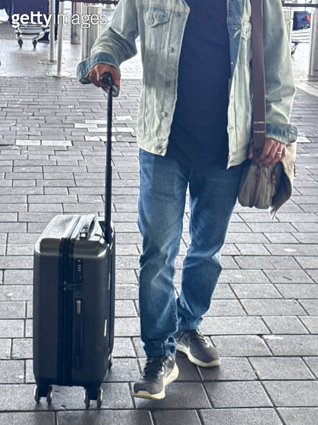 Image of unrecognisable passenger wearing denim jacket and shoulder bag ...