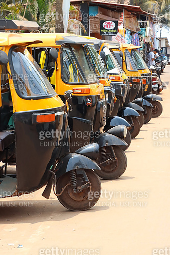 Close-up image of Indian auto rickshaws lined up, black and yellow tuk ...