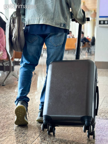 Image of unrecognisable passenger wearing denim jacket and shoulder bag ...