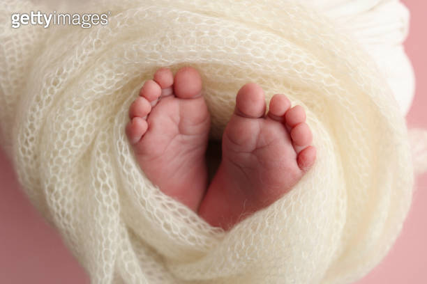 The tiny foot of a newborn. Soft feet of a newborn in a white woolen ...