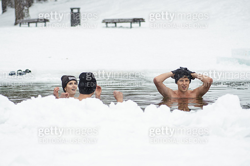 Young friends ice bathing in cold water of a frozen lake (1934706739 ...
