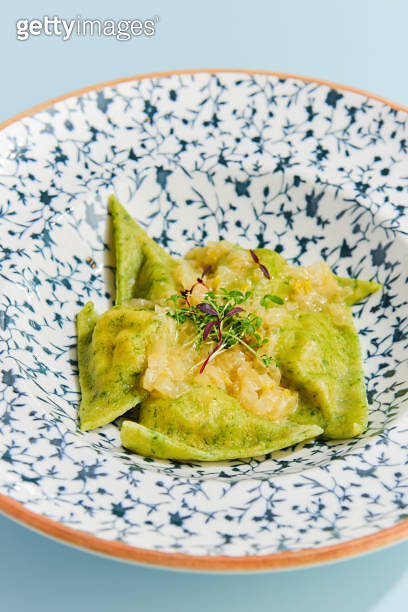 Gourmet Shrimp Ravioli with Green Dough on Elegant Floral Plate 이미지 ...