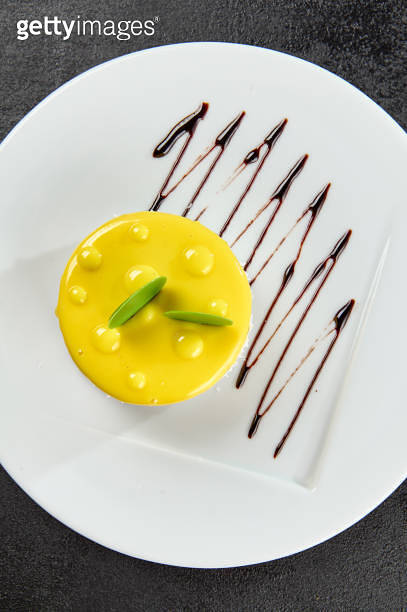 Mini mango cake on white plate on black concrete background. Mango ...
