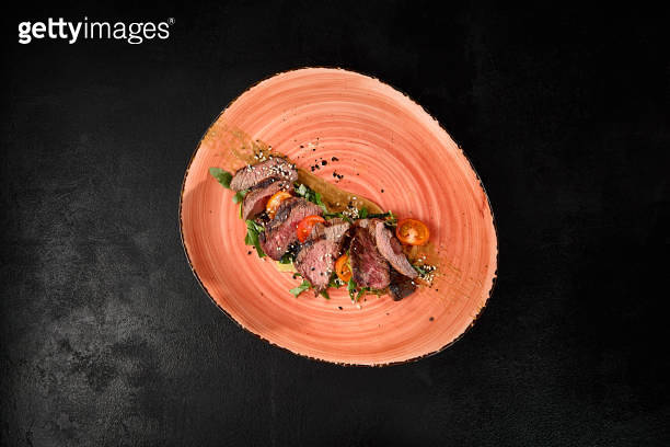 Sliced Beef Roast with Cherry Tomatoes and Arugula on Rustic Plate ...