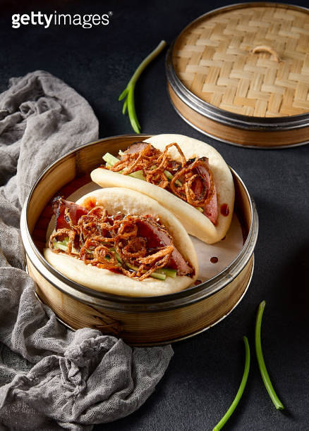 Gourmet Bao buns with roast beef and crispy fried onions; a modern ...