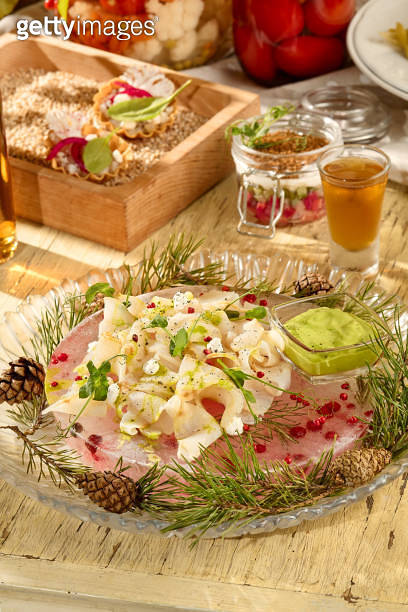 Stroganina of fish on ice garnished with pine branches, a classic ...