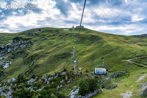 Chairlift or cable car riding over Stoos village and mountain landscape ...
