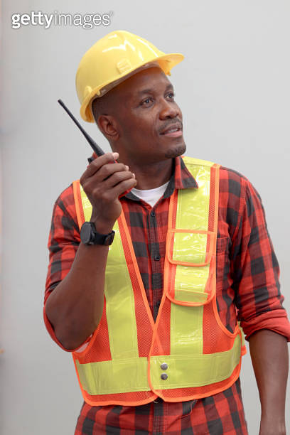 Portrait of young African worker man wearing safety vest and helmet ...