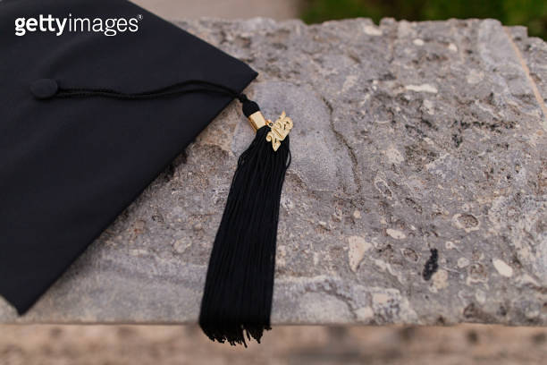 A Black Graduation Cap & Tassel with a Gold 2025 Charm While Lying on a ...