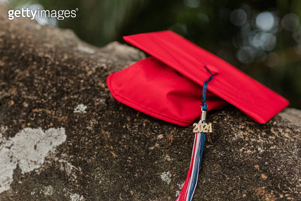Vibrant Red Graduation Cap with a Red, White, & Blue 2024 Tassel Lying ...