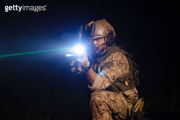Soldiers in uniforms aiming their rifles ready to fire during military ...