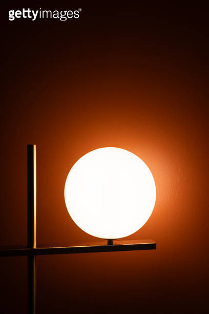 Round lamp, full moon shape with the light bulb inside shining on the ...