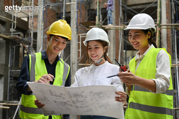 The female chief engineer and her assistant discuss building plans with ...