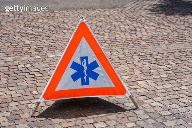 Mobile ambulance emergency road sign standing on cobblestone town ...