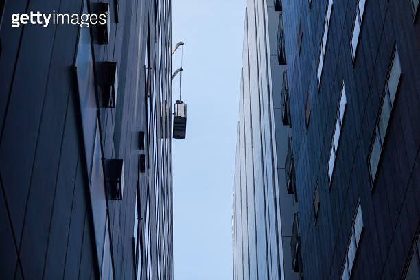 Cleaning windows of high-rise buildings in the valleys between ...