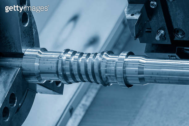 The CNC lathe machine forming cutting the metal screw shaft parts in ...