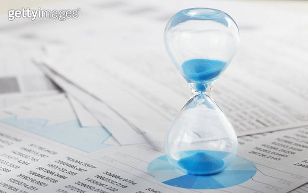 Best time for investment. Hourglass, financial charts and calculator ...