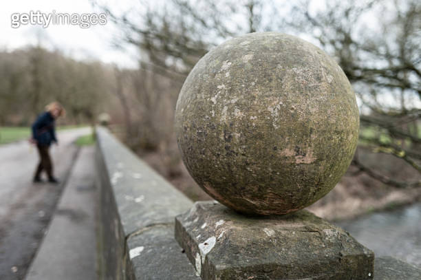 Shallow focus of a very old, ornate stonework sphere seen as decoration ...
