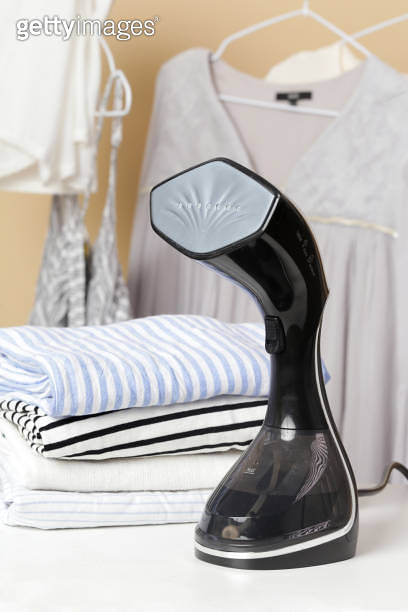 Upright garment steamer. Close up of vertical steamer with clothes ...
