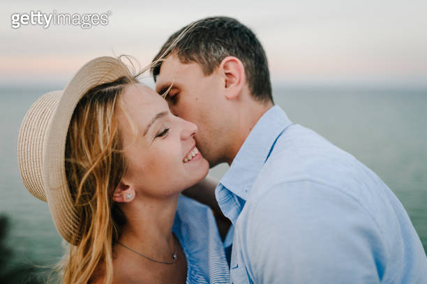 Man and woman kiss and embrace on sand sea spending time together ...