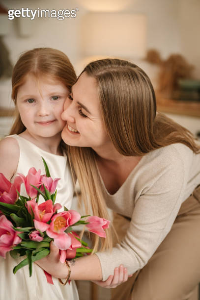 Beautiful daughter gives mother big bouquet of tulip flowers and makes ...