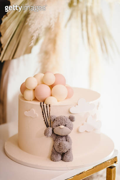 Cake with bear and balloons. Trendy cake for celebration baptism. Delicious reception at a ...