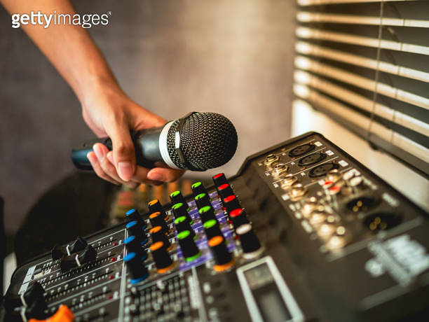 Hand Sound engineer holding microphone on sound mixer in live ...