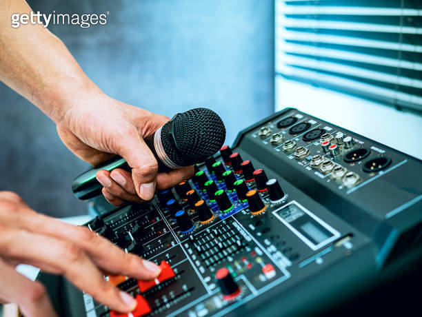 Hand Sound engineer holding microphone on sound mixer in live ...