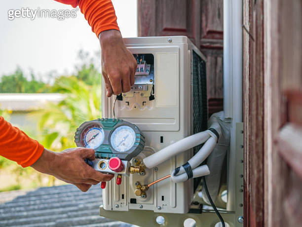 Air conditioning technicians install new compressor air using monitor ...