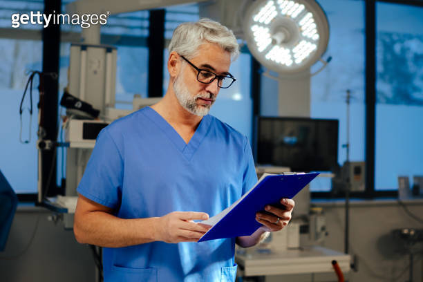 Portrait of confident ER doctor standing in hospital emergency room ...