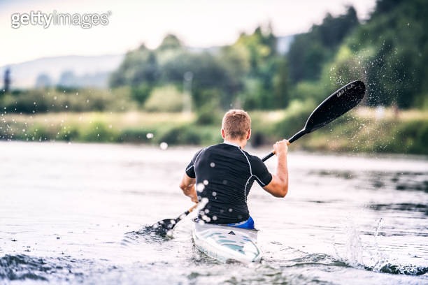 Canoeist man sitting in canoe paddling, in water. Concept of canoeing ...