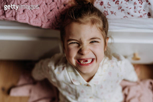 Portrait of cute girl smiling with gap-toothed grin, missing her baby ...