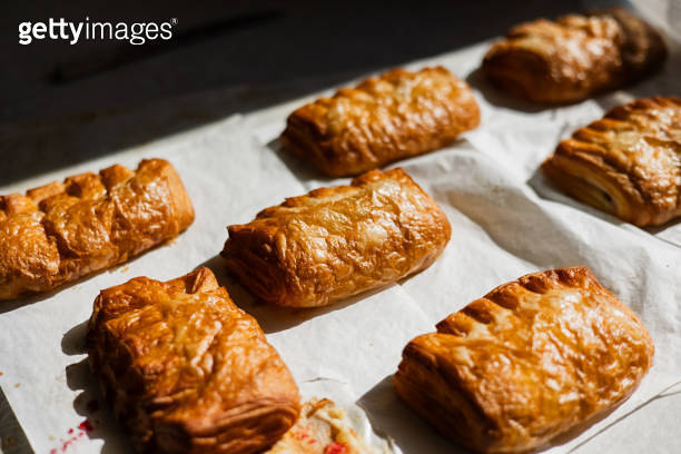The appetizing crispy freshly baked sweet buns in the sun's rays in the ...