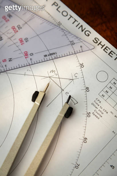 Above image of a navigator's radar plotting chart with a triangle and compass divider 이미지 ...
